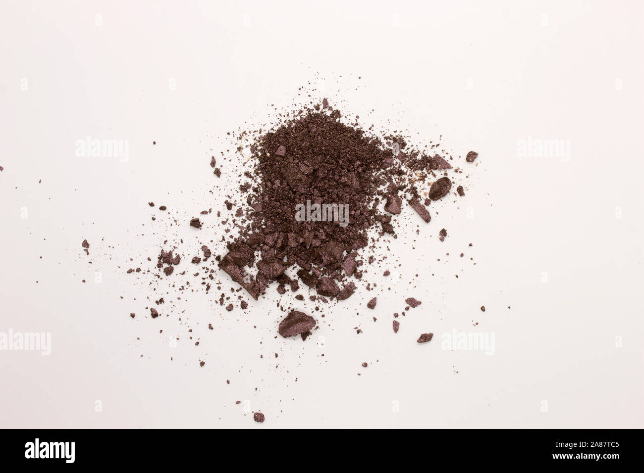 This is a photograph of a Dark Purple powder Eye shadow isolated on a ...