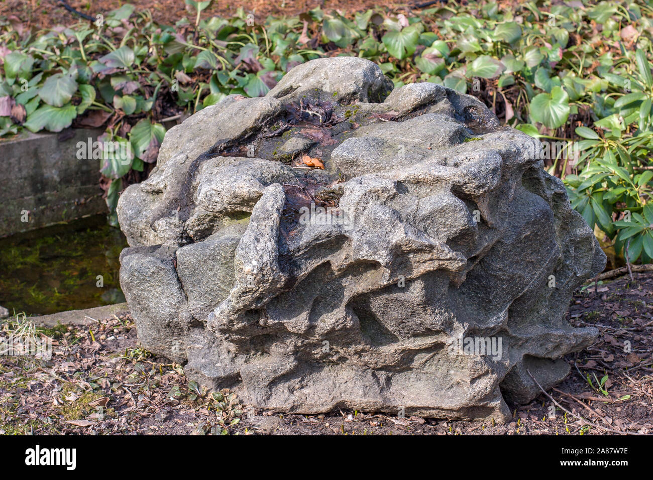 Large gray shapeless stone with traces of erosion on the ground close ...