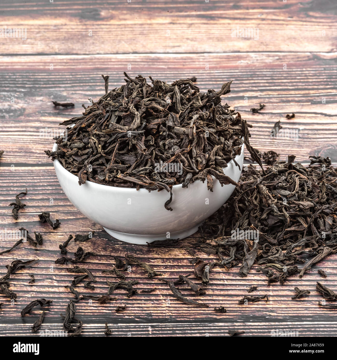 Dried tea is poured into a ceramic cup on a wooden plank table Stock ...