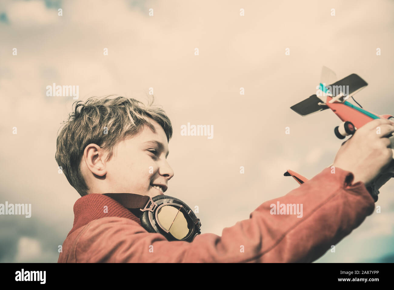 Little boy playing with a small plane in a sunny day, dreaming about ...