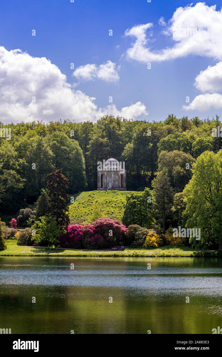 The circular Temple of Apollo looks out over colourful rhododendron ...