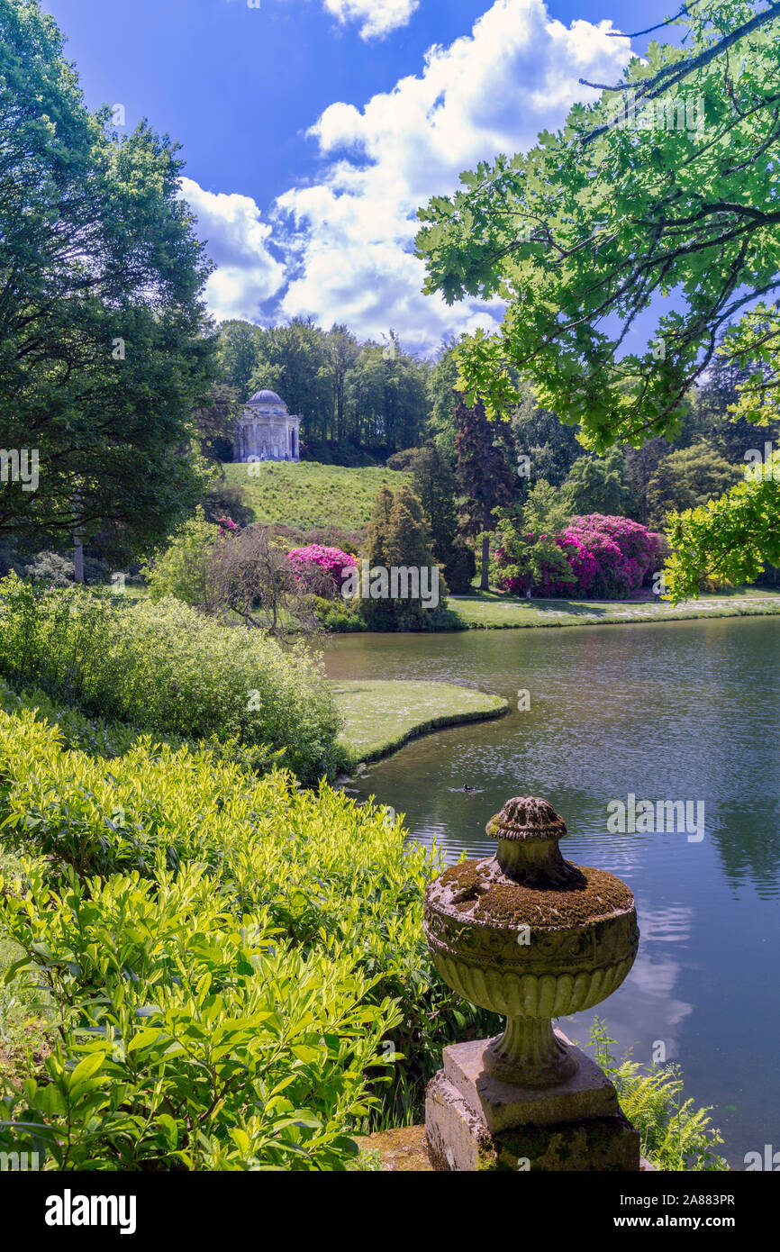The circular Temple of Apollo looks out over colourful rhododendron ...