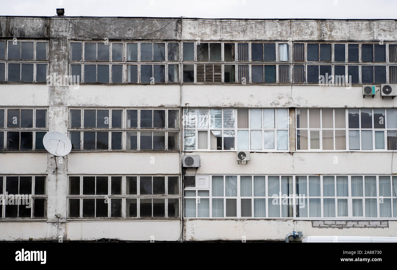 The front view on a facade of building with wall and windows in soviet ...