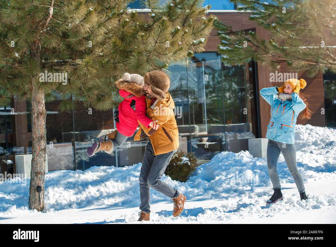 Winter vacation. Family time together outdoors playing snowballs ...