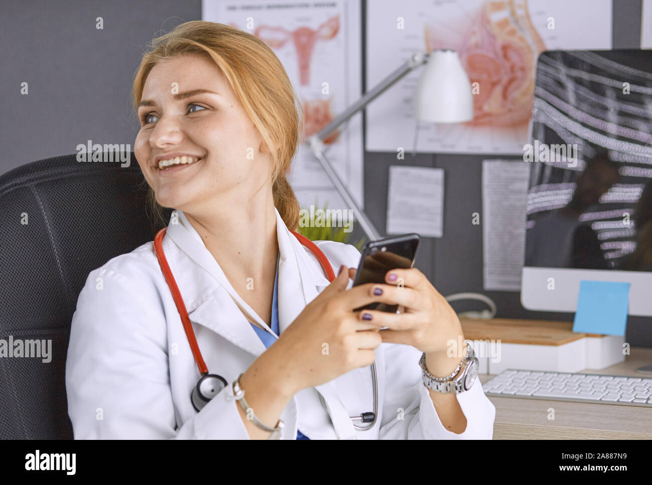female doctor between patients in the office talking on the phone Stock ...
