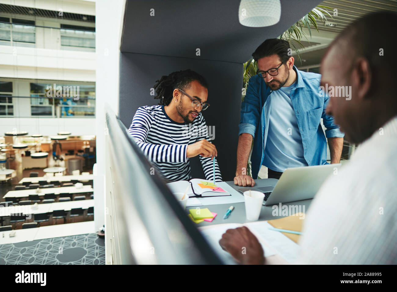 Diverse group of businessmen going over notes while working together in ...
