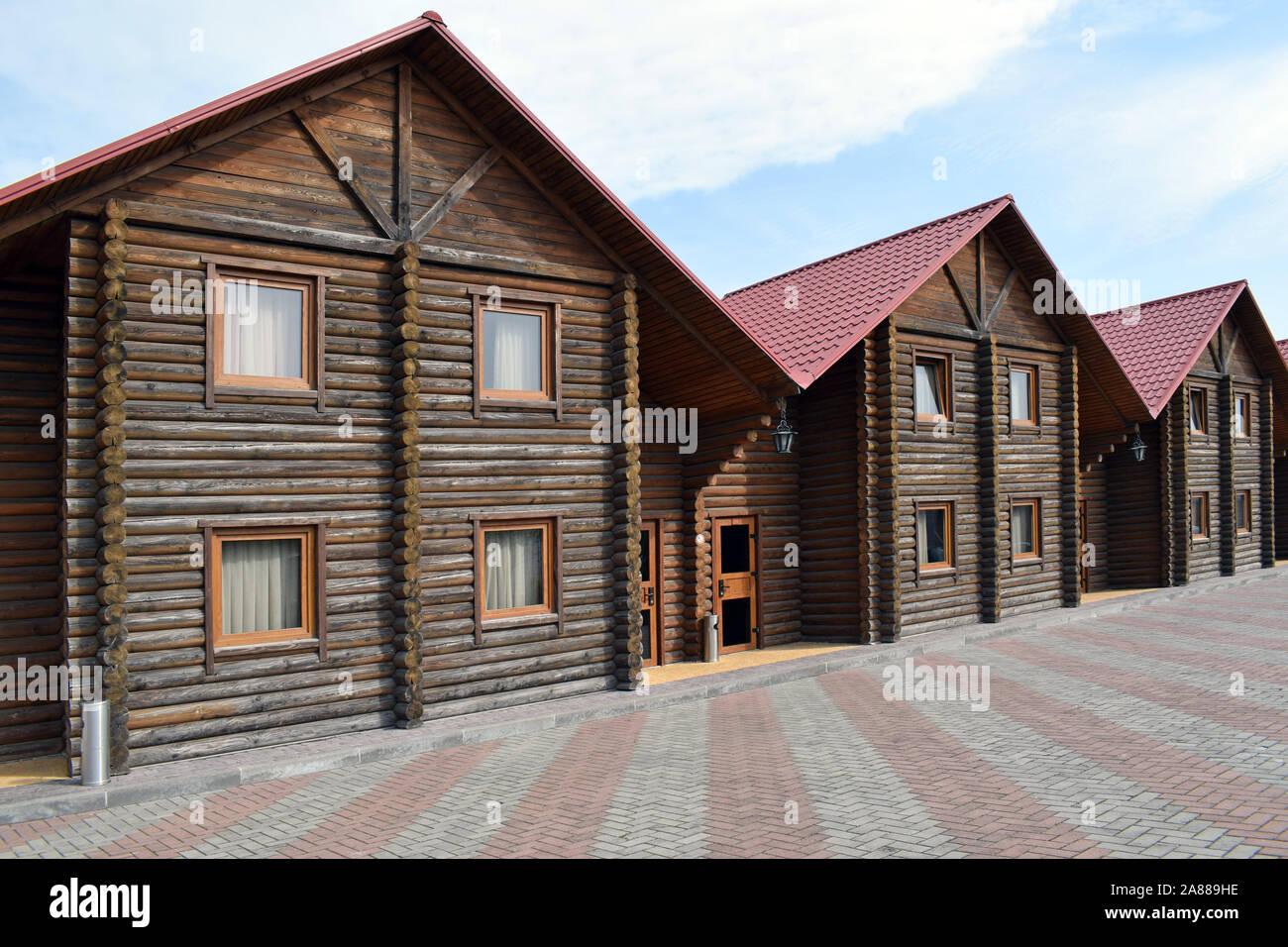 Wooden log houses. Wooden mini hotels on a background of blue sky ...