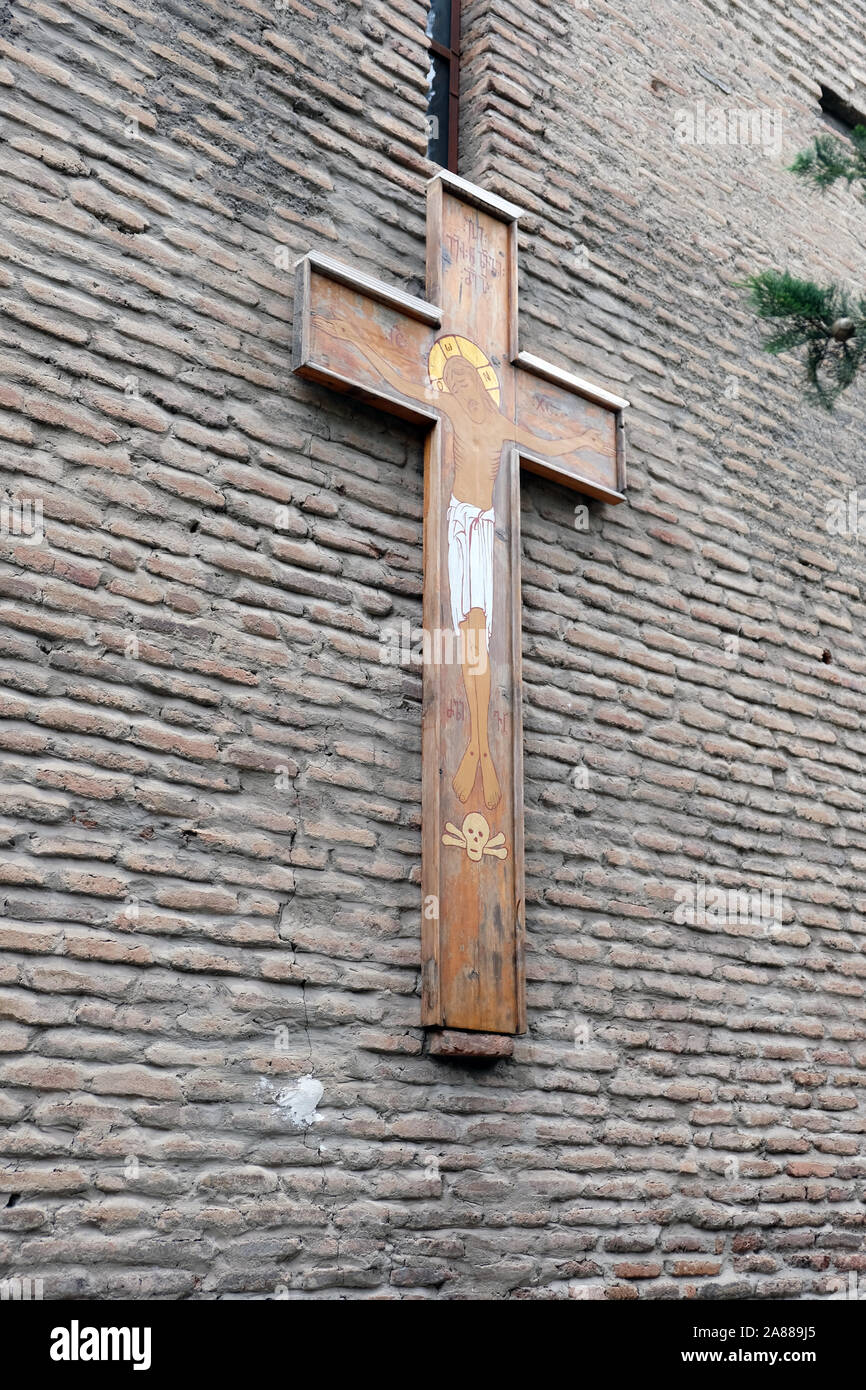 Natural wooden cross on a brick wall. Cross on the wall of an ancient ...