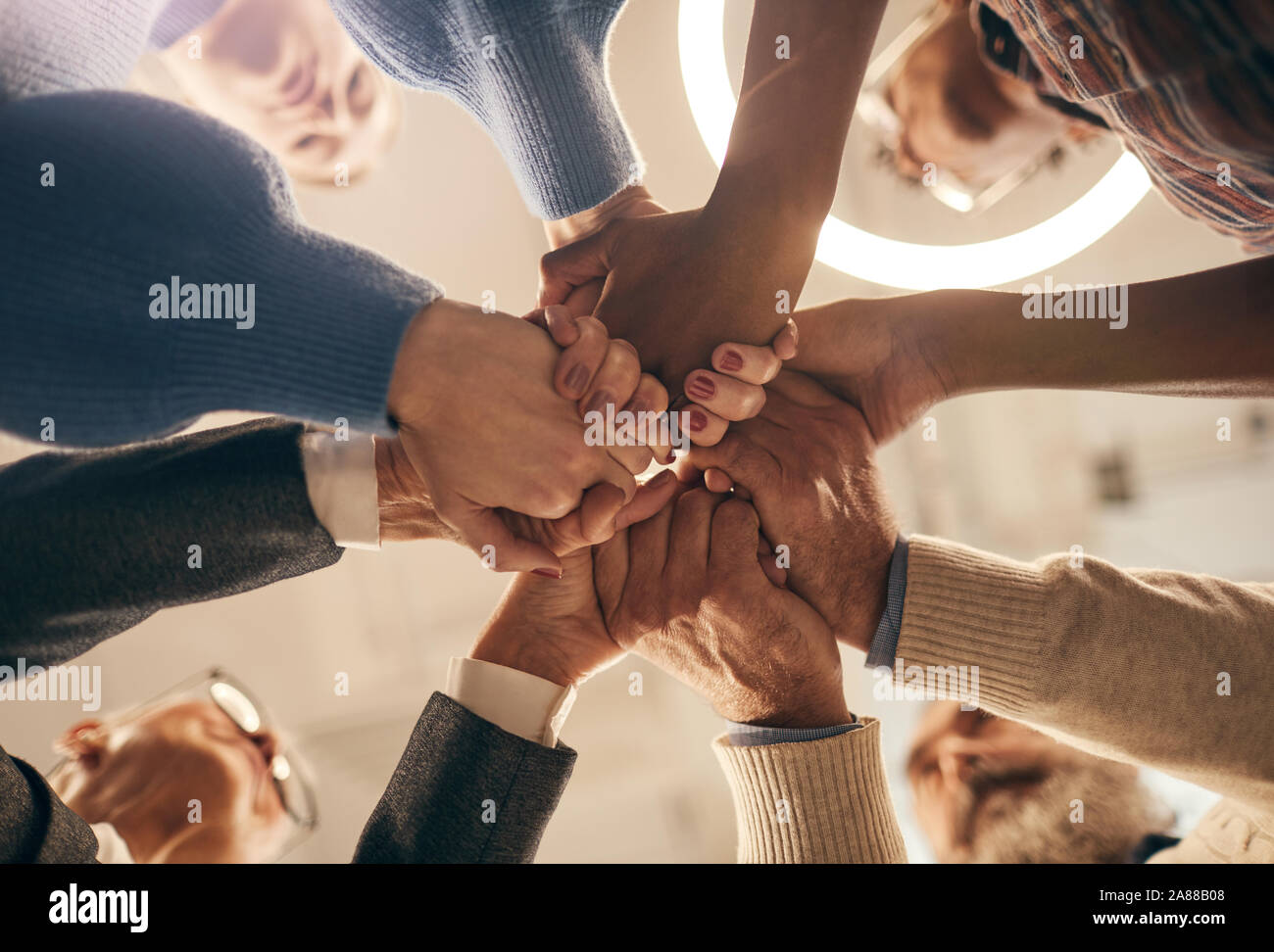 Low angle view of people holding hands they supporting each other ...
