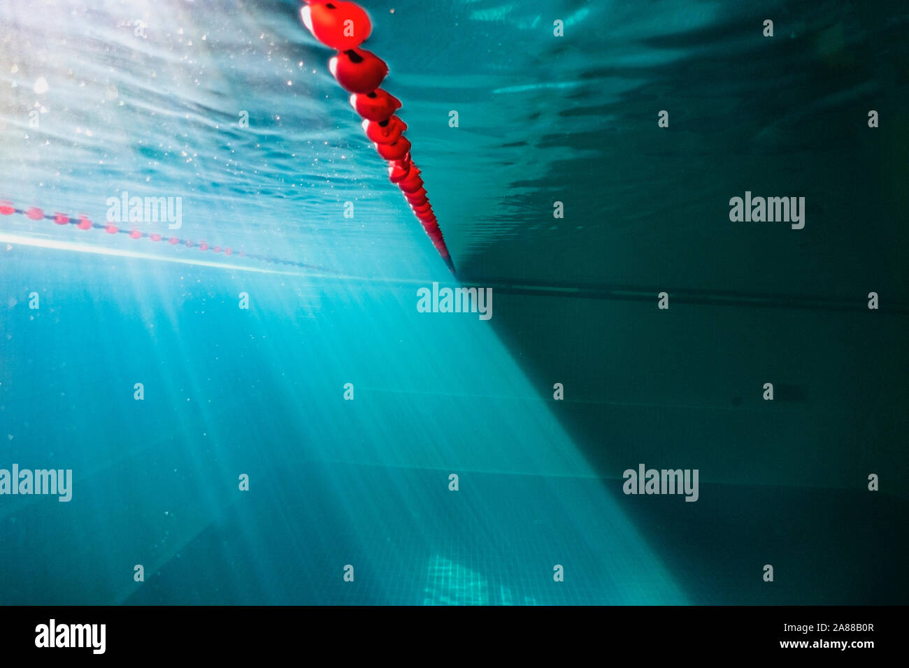 Rays of the sun underwater in a deep pool. Refraction and reflection of ...