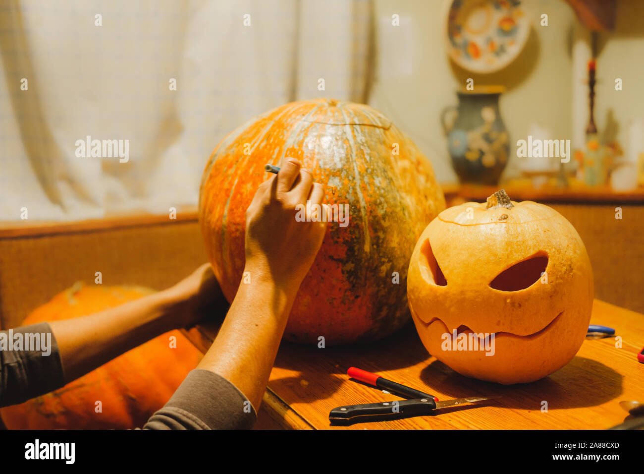Preparing halloween pumpkins for carving. Marking and carving large ...