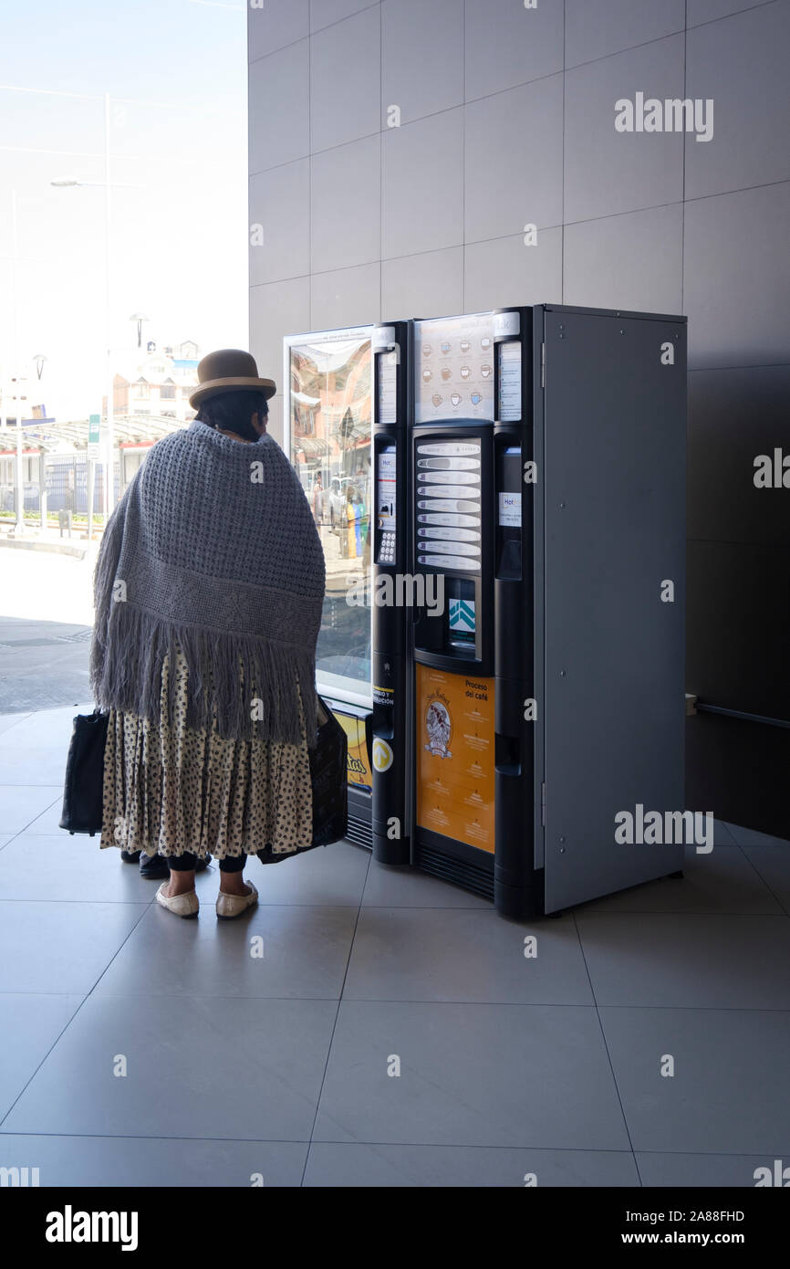 Local woman wearing a classic bowler hat dealing with a coffee vending ...