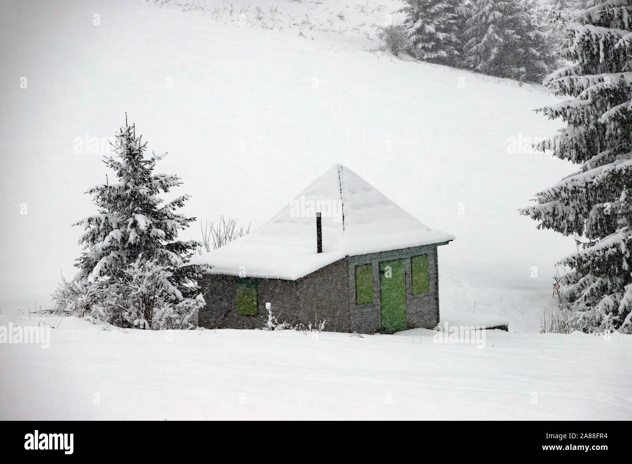 Small wooden hut in winter forest in heavy snowfall Stock Photo - Alamy