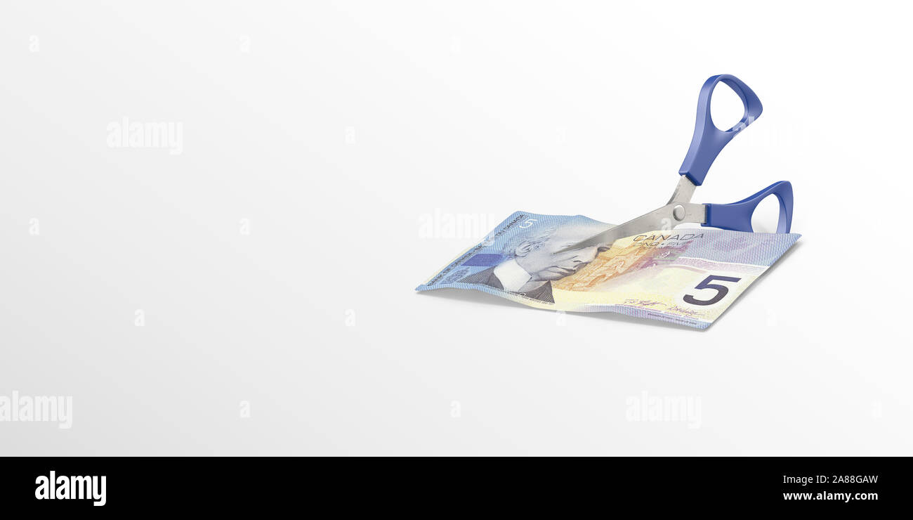 Ten Canadian Dollar bill is cutting to half by a blue scissors ...