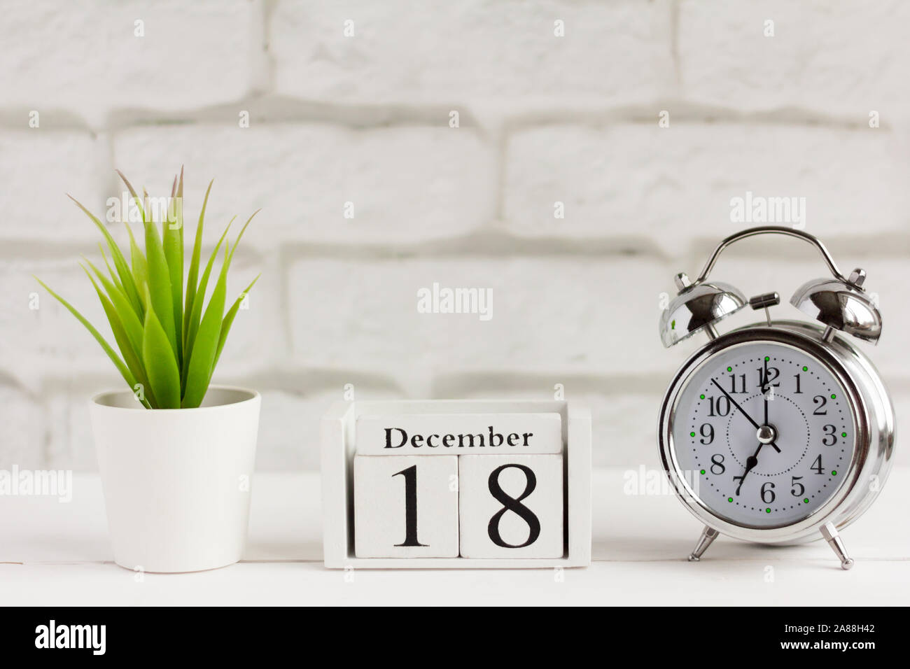 calendar of white wooden cubes and alarm clock on the table, December ...