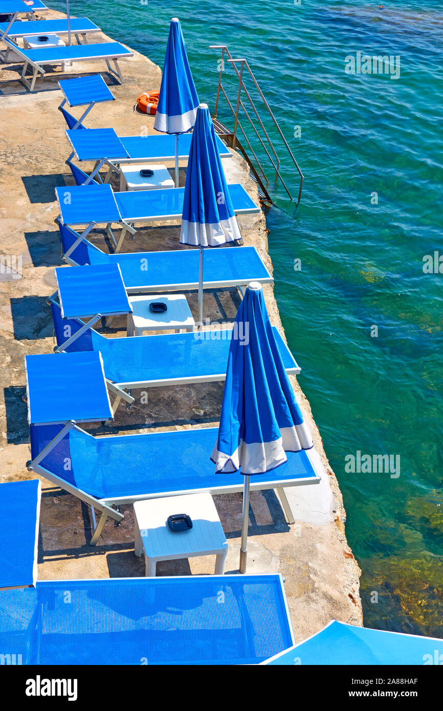 Beach with blue sunbeds in the row by the sea Stock Photo - Alamy