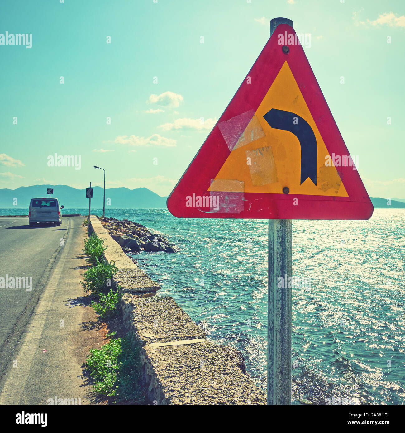Road sign on corner of road by the sea. Vintage style toned image Stock ...