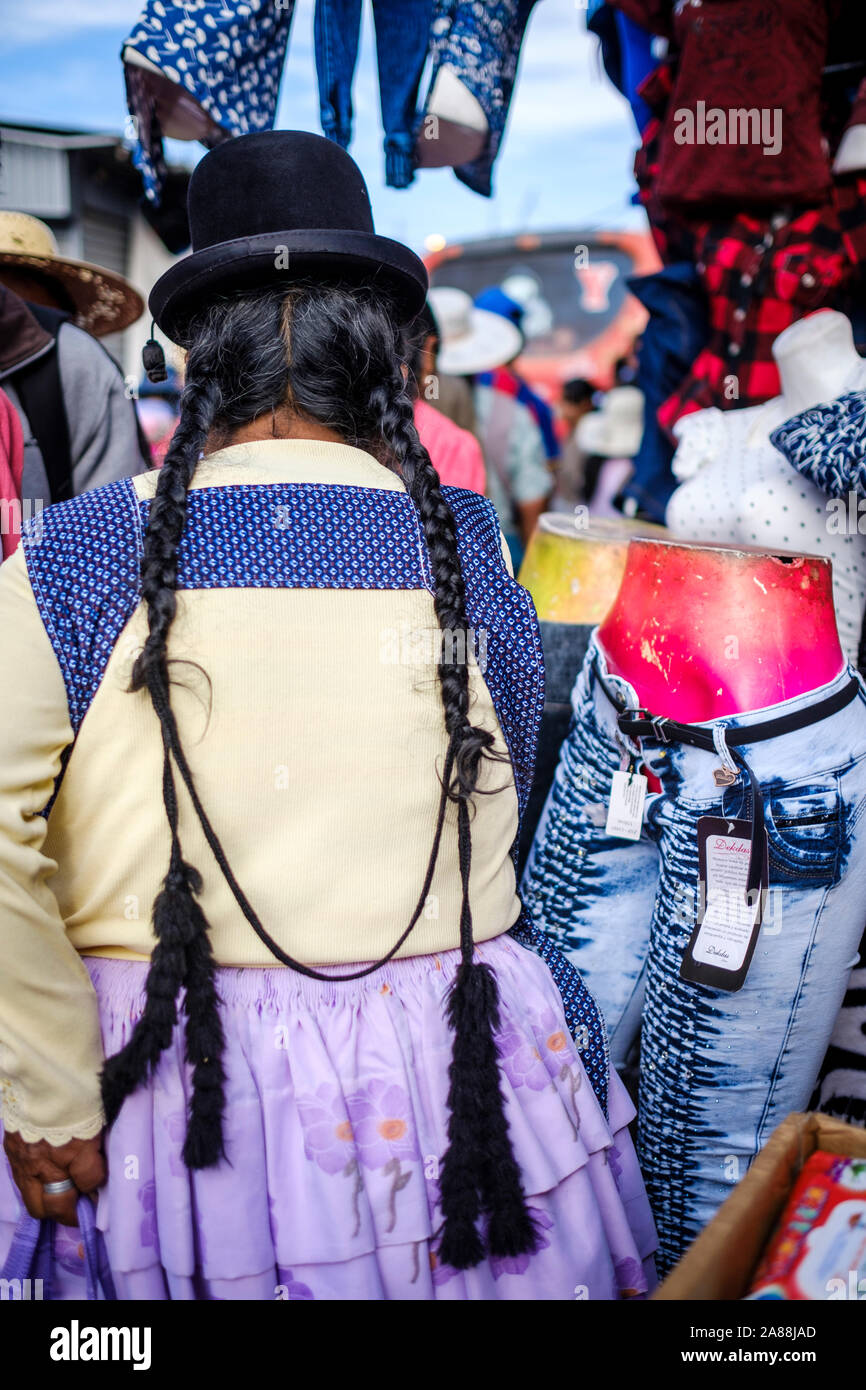 Woman wearing traditional braids and bowler hat walking on the Old ...