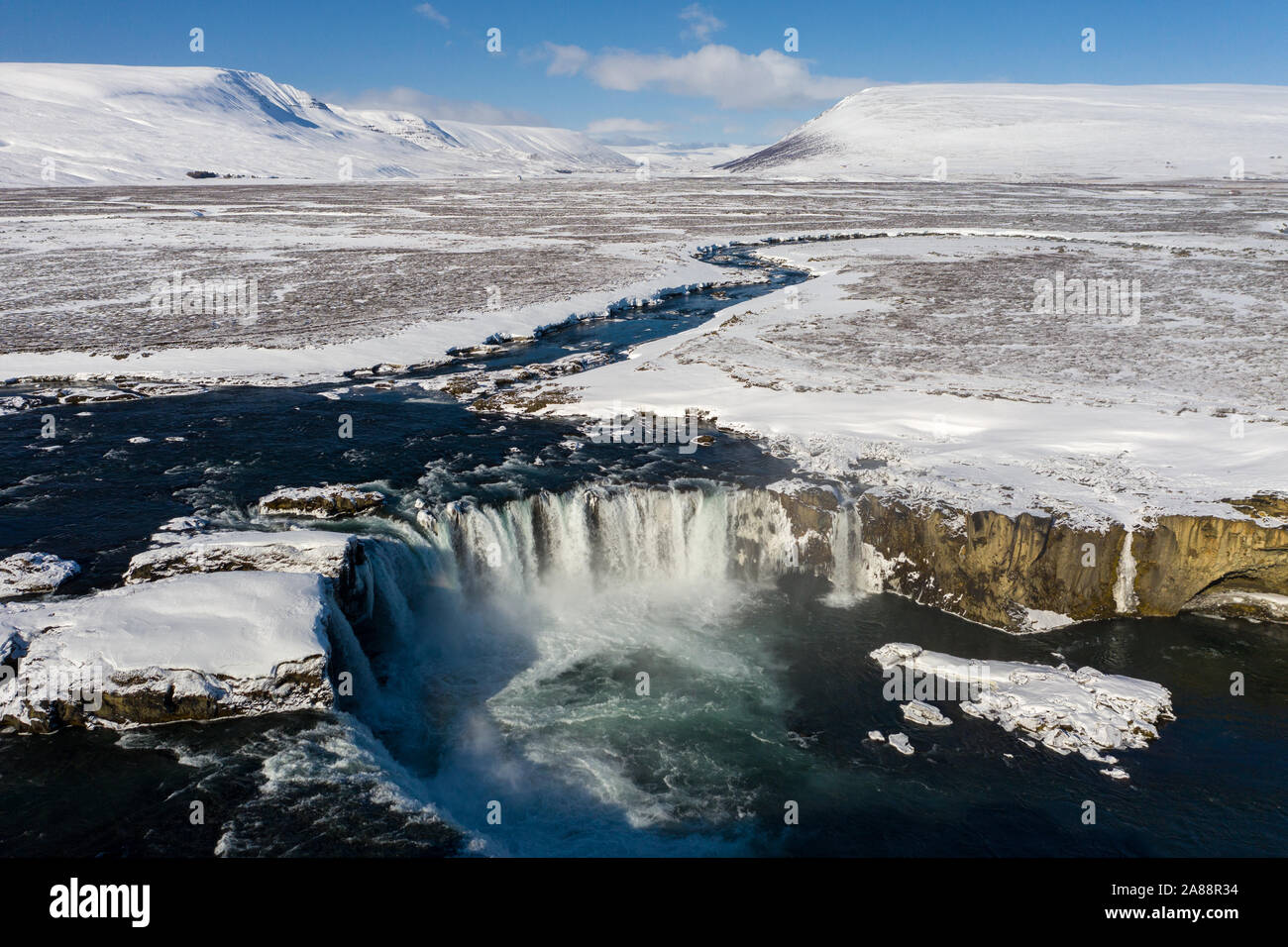 Aerial view of Godafoss waterfall, snowy shore and river. Iceland in ...
