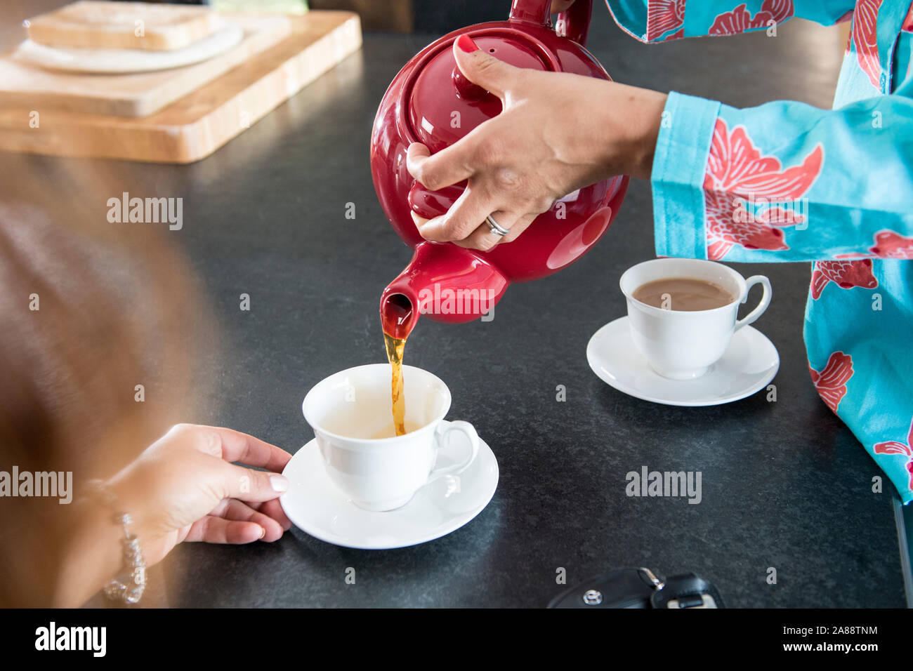 Tea time Pouring English tea from a teapot cup of tea Stock Photo - Alamy
