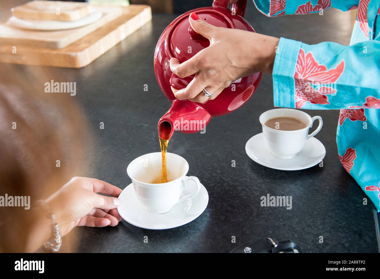 Tea time Pouring English tea from a teapot cup of tea Stock Photo - Alamy