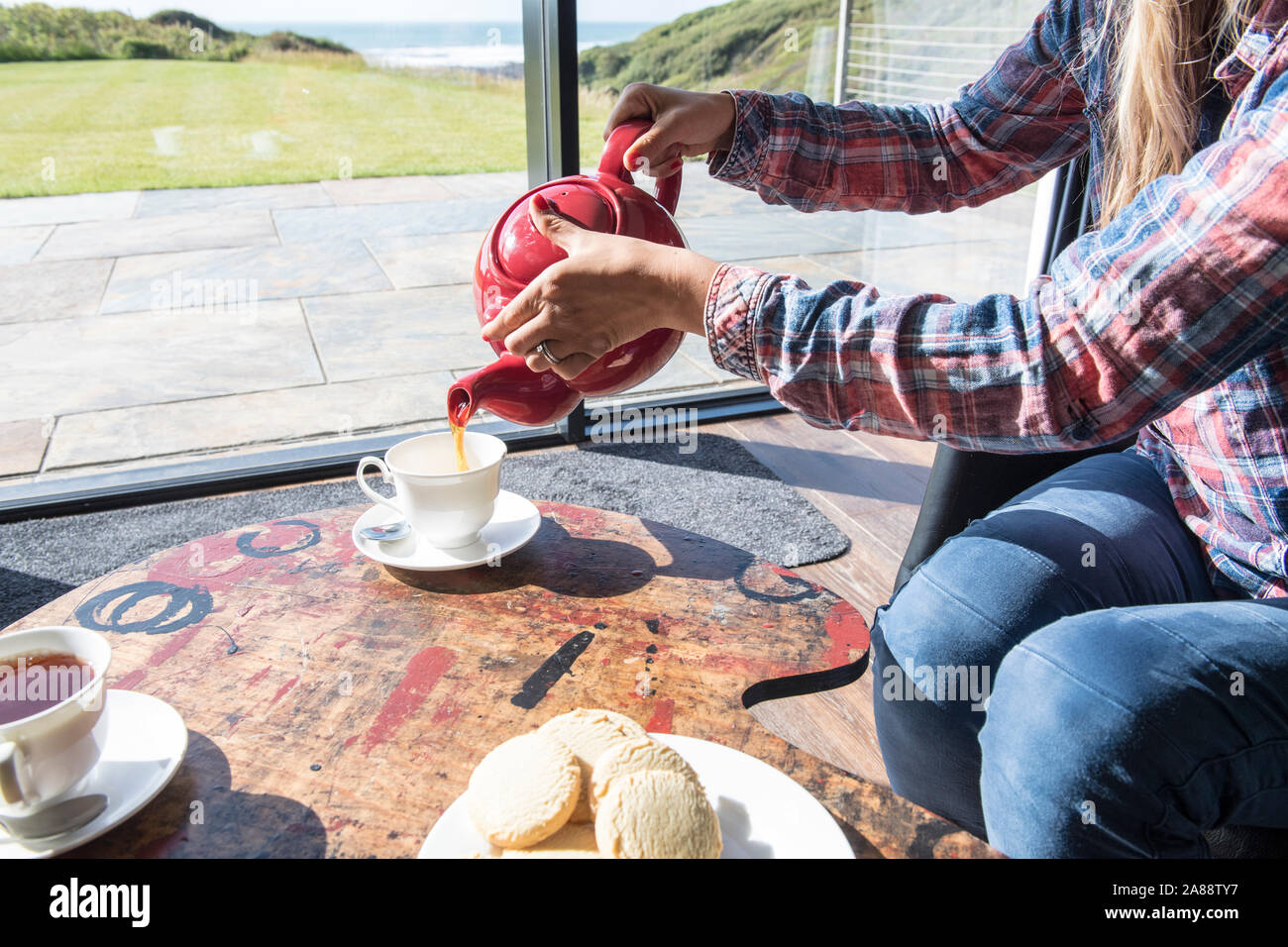 Tea time Pouring English tea from a teapot cup of tea Stock Photo - Alamy