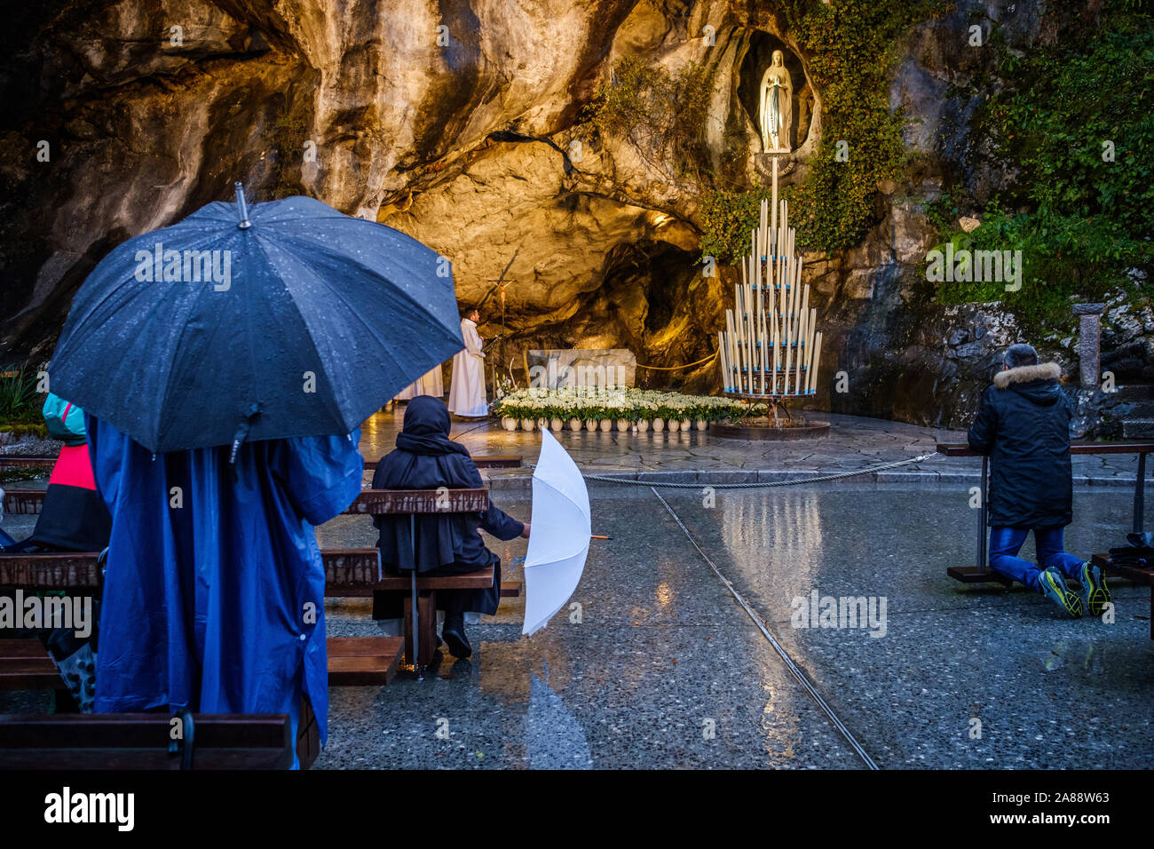 Lourdes (south-western France). Pilgrims praying under the rain at the ...