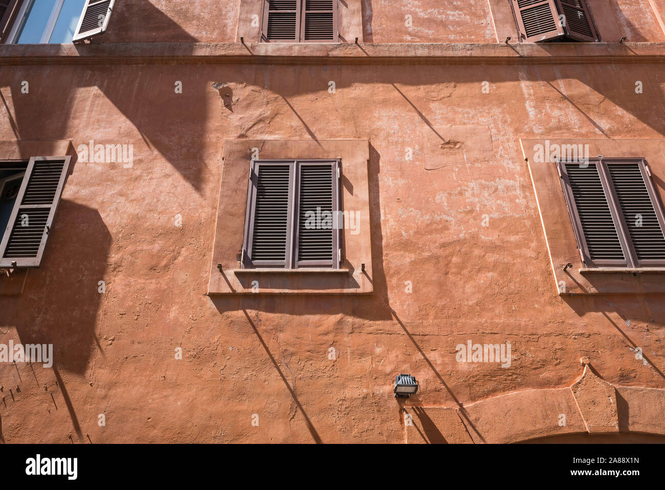 Ancient Roman buildings wall with wooden windows under the sunlight ...