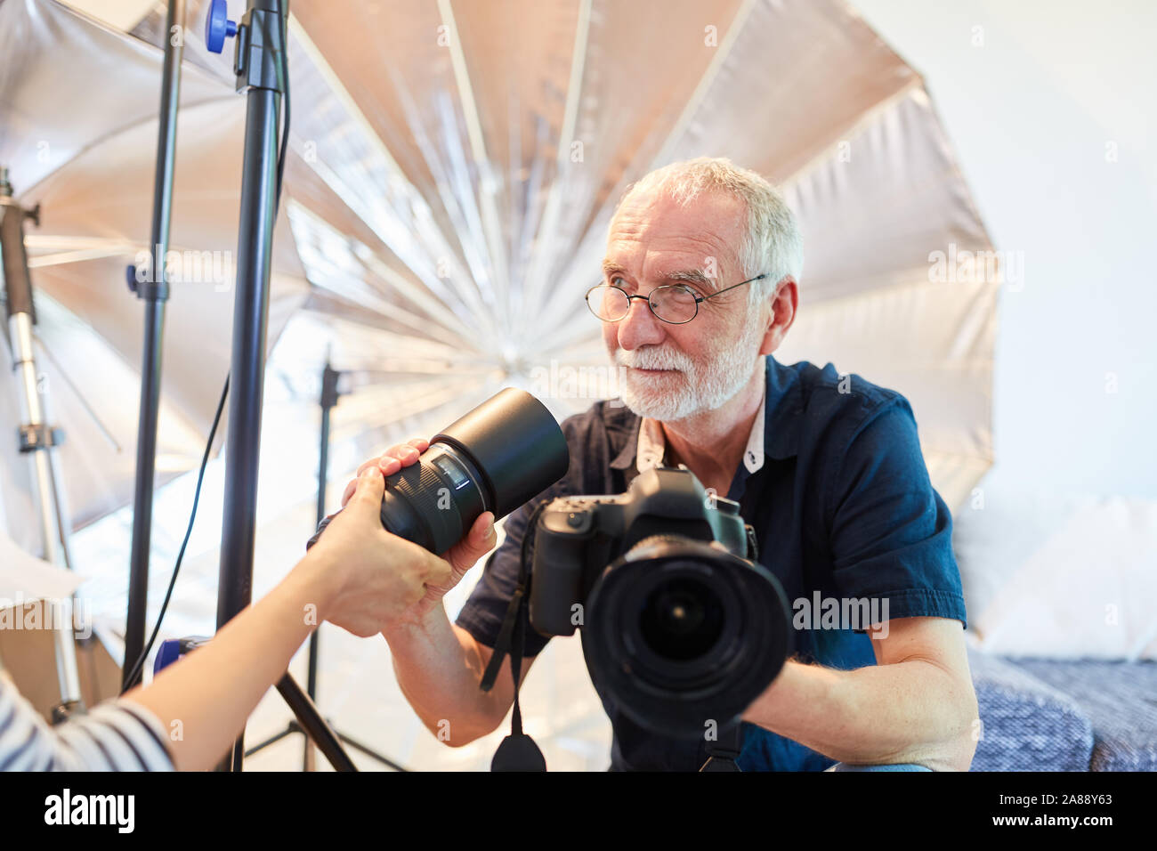 Photographer chooses a new camera lens at the photo shoot in the photo ...