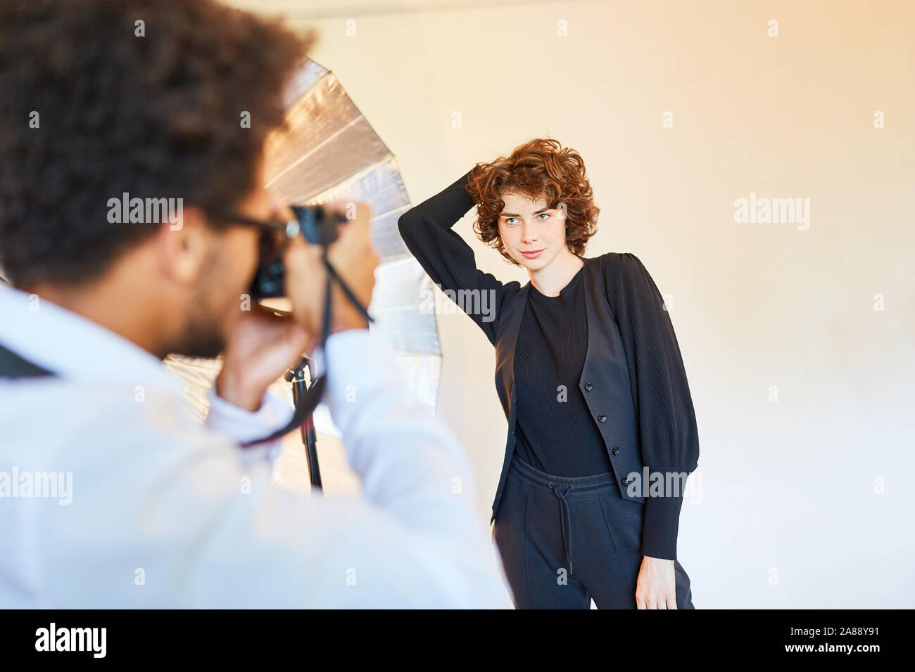 Young woman as a model posing at the photo shoot in the photo studio ...