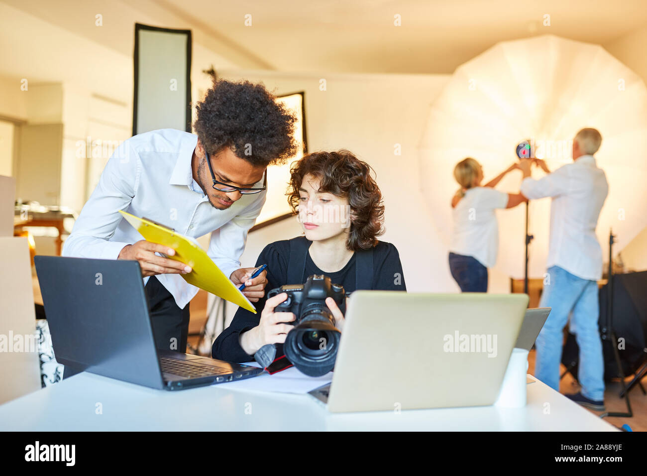Photo assistant with clipboard and photographer with camera in the ...