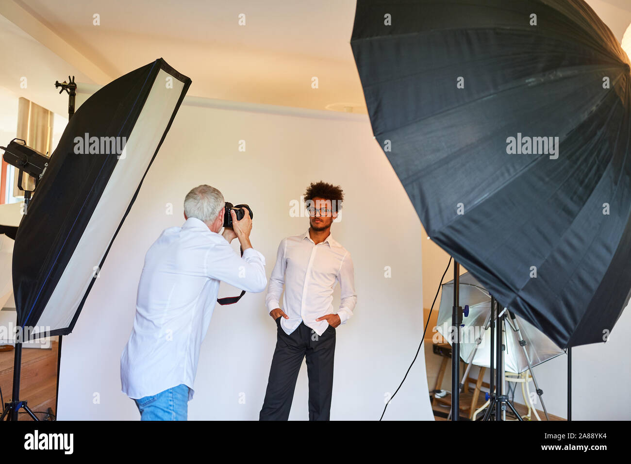 Portrait photographer in the photo studio makes portrait photos of ...