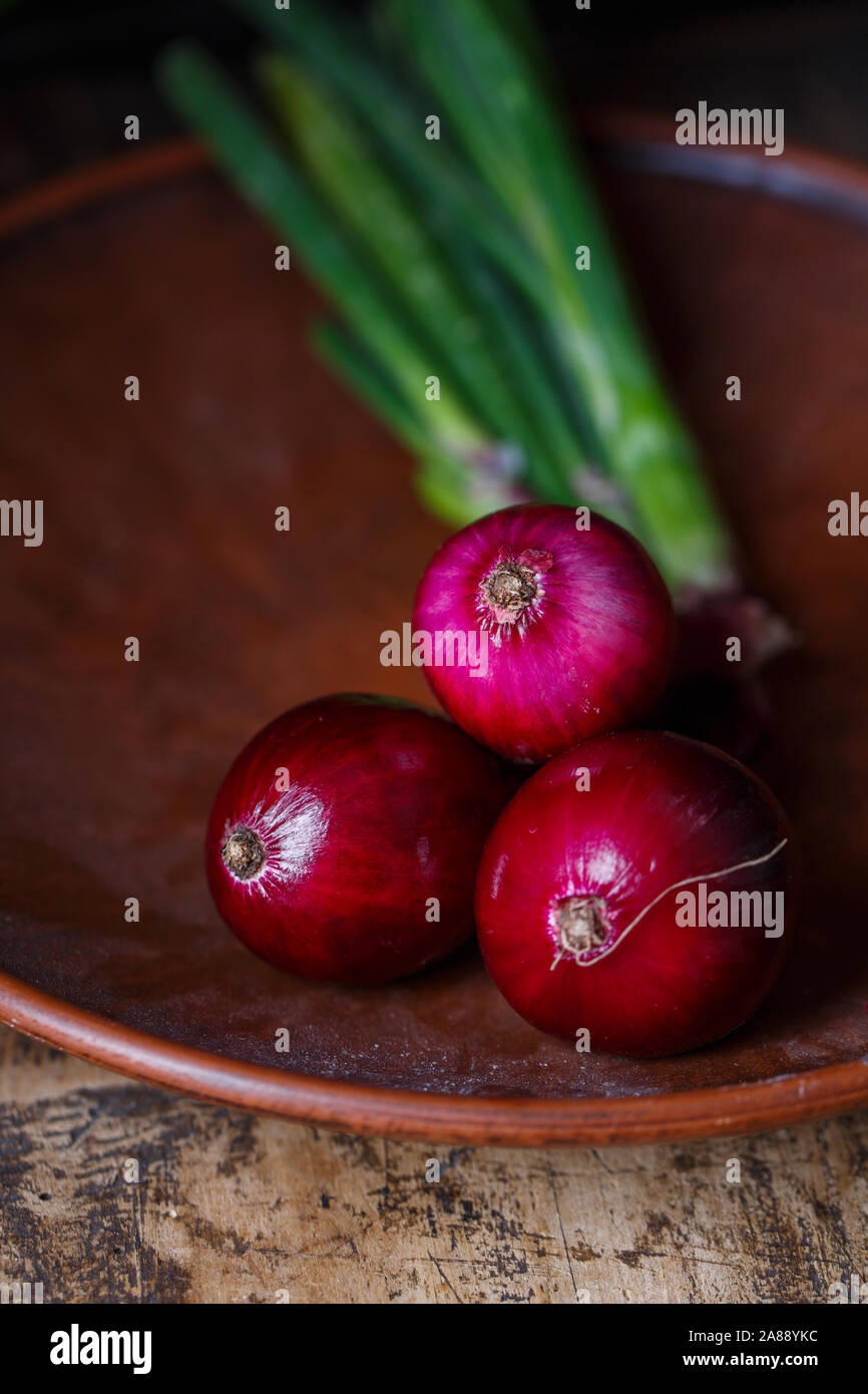 Three red onions on a flat plate Stock Photo - Alamy