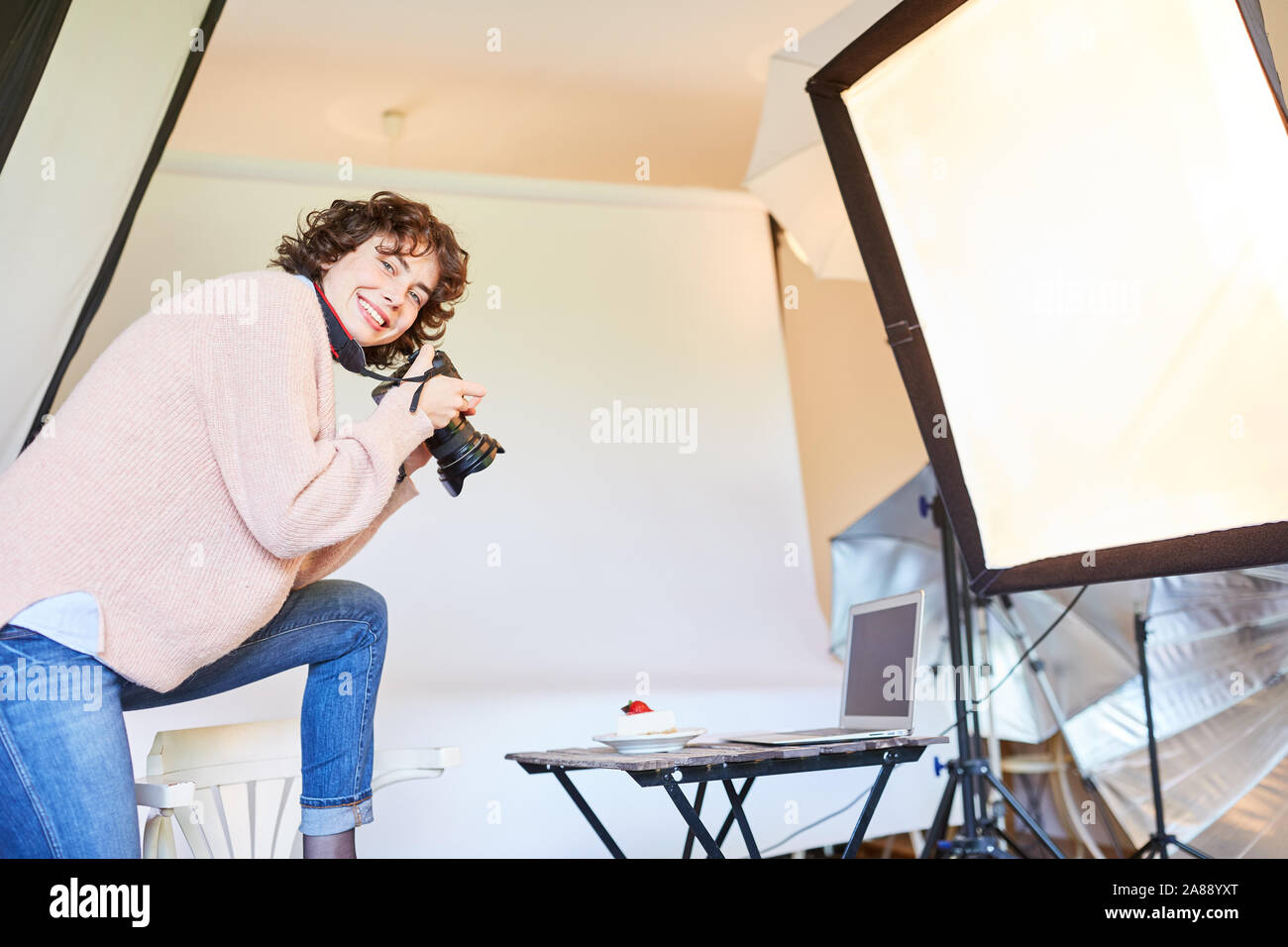 Young food photographer with camera at the photo shoot in the photo ...