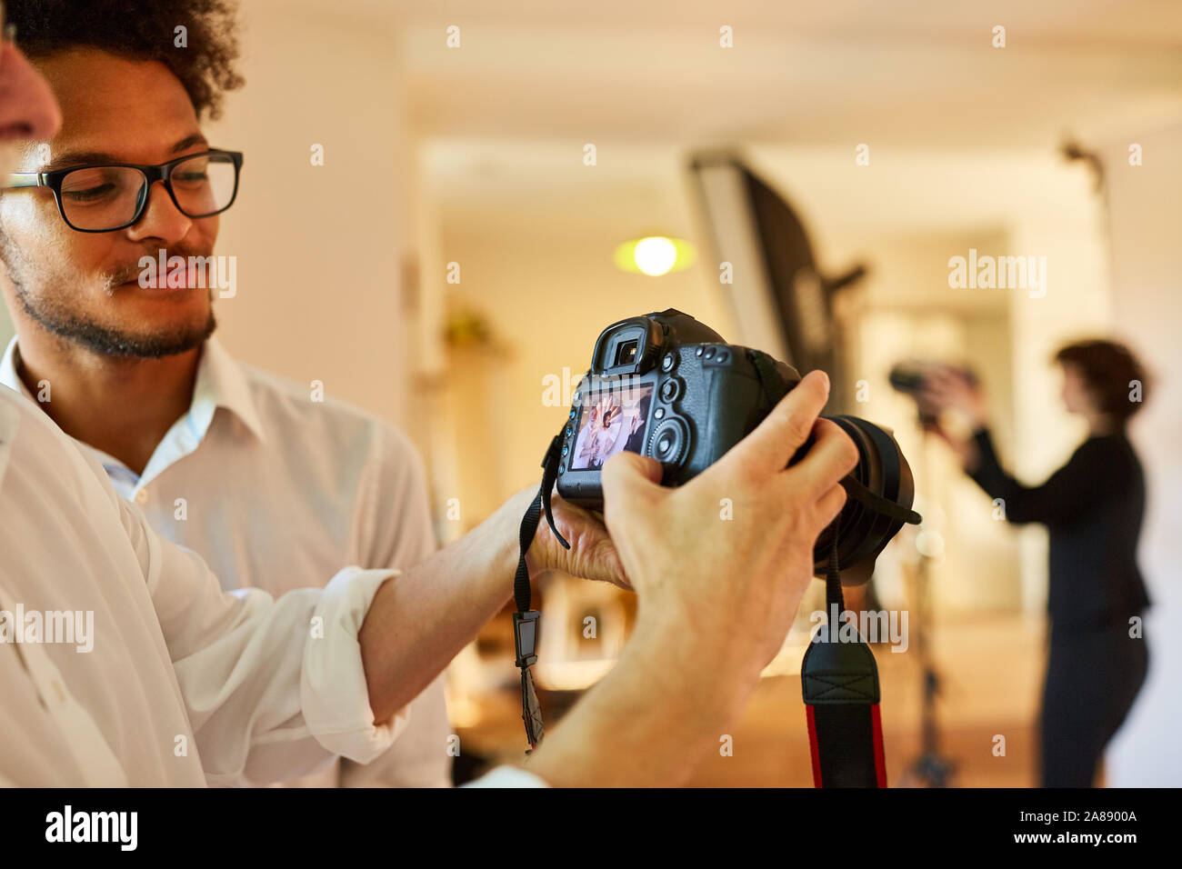 Photographers inspect camera display after a photo shoot Stock Photo ...