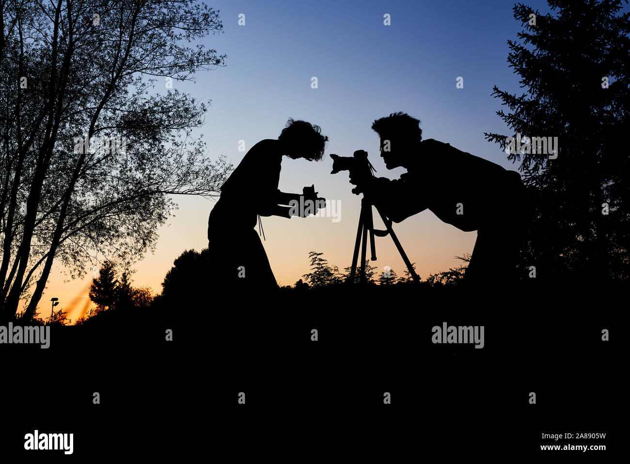 Young couple as hobby photographers take portrait photos at dusk Stock ...