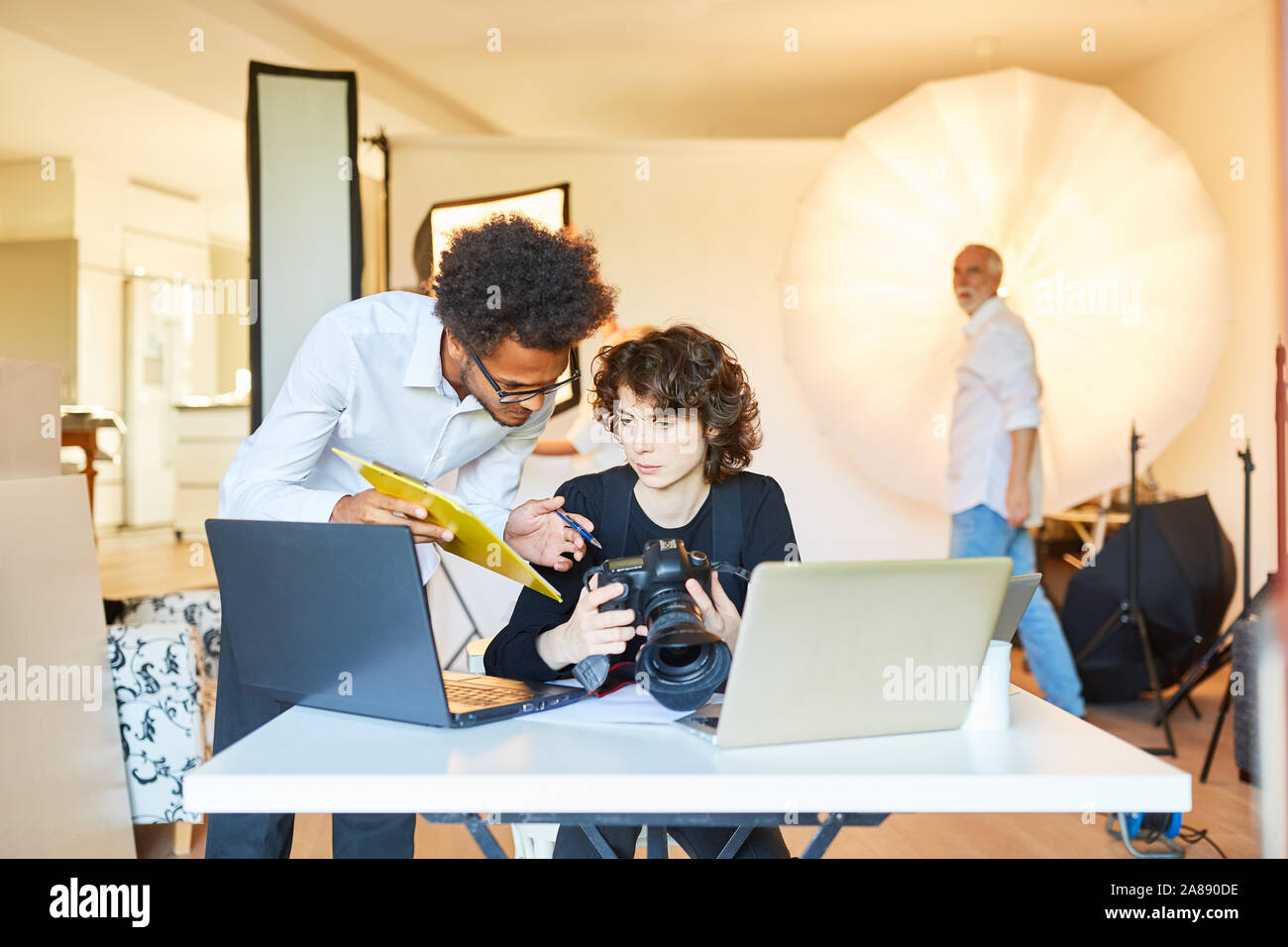 Photo assistant with checklist and photographer on laptop plan ...