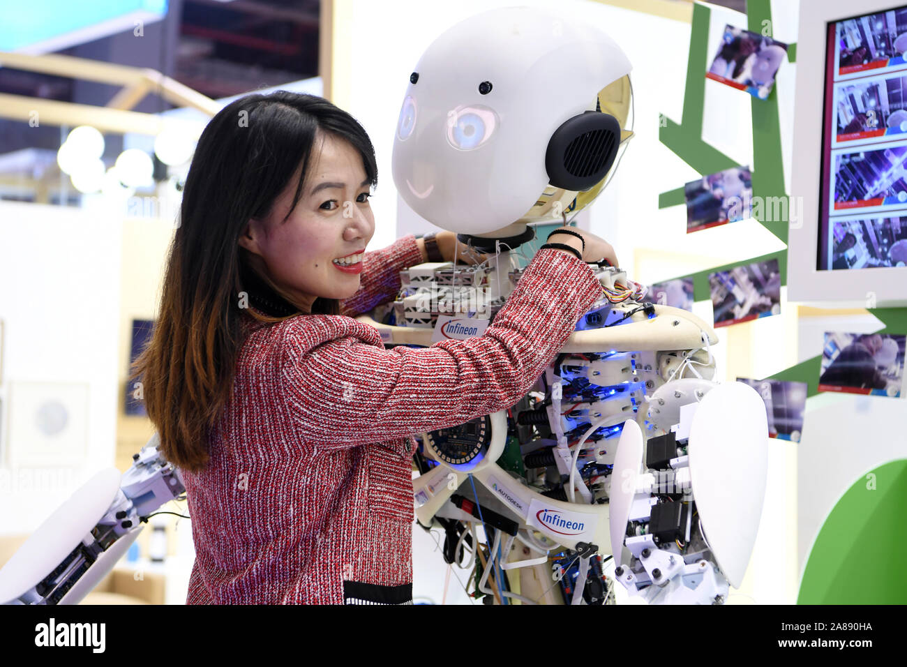 Shanghai, China. 7th Nov, 2019. A visitor poses for a photo with Roboy ...
