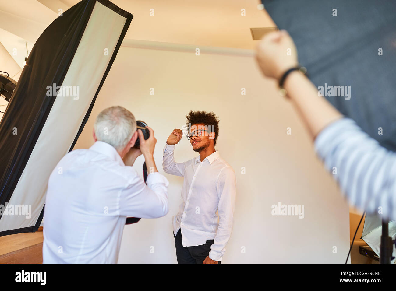 Man as a model poses for photographer during photo shoot for portrait ...