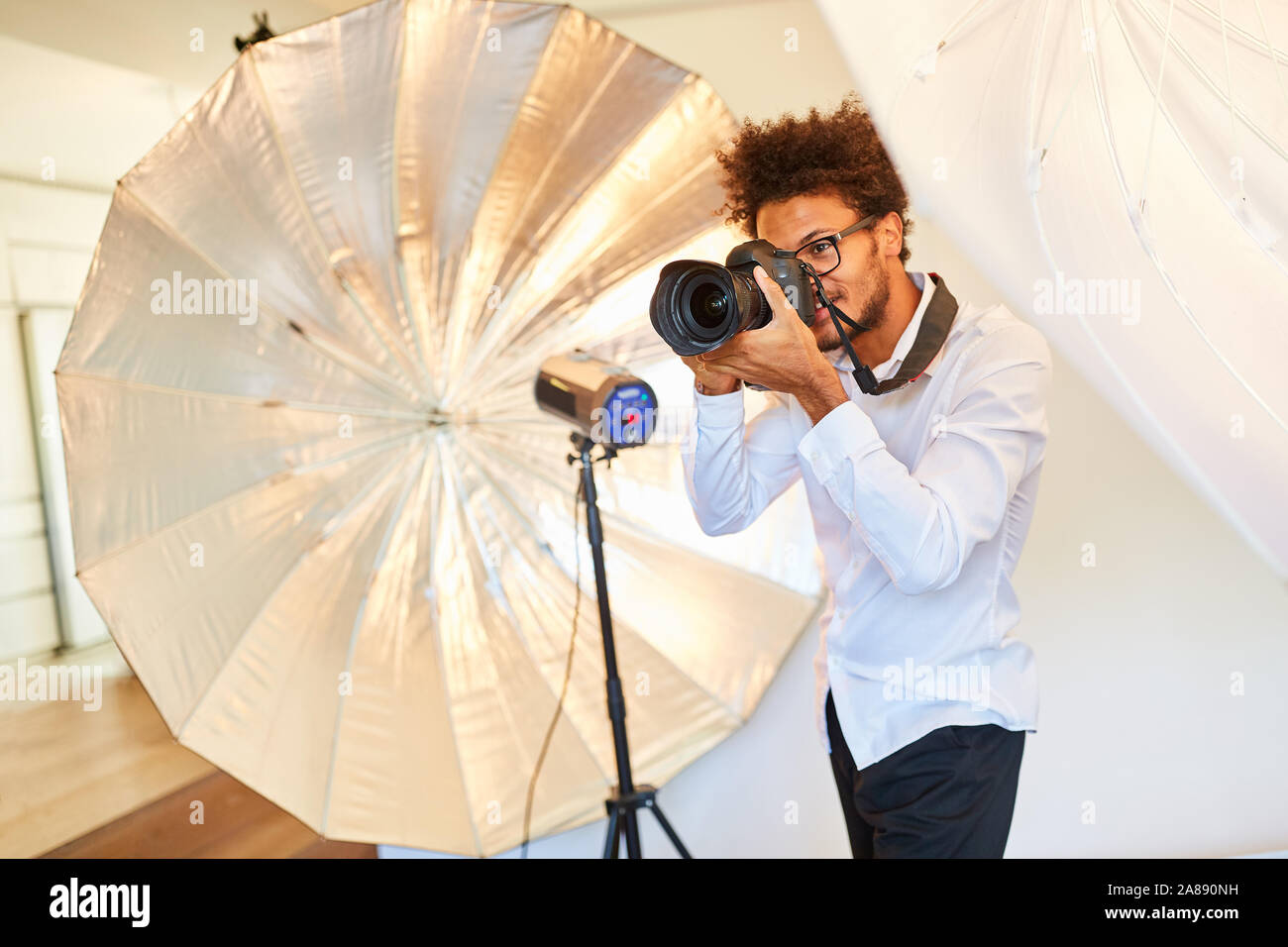 Creative young photographer with digital camera at the photo shoot ...