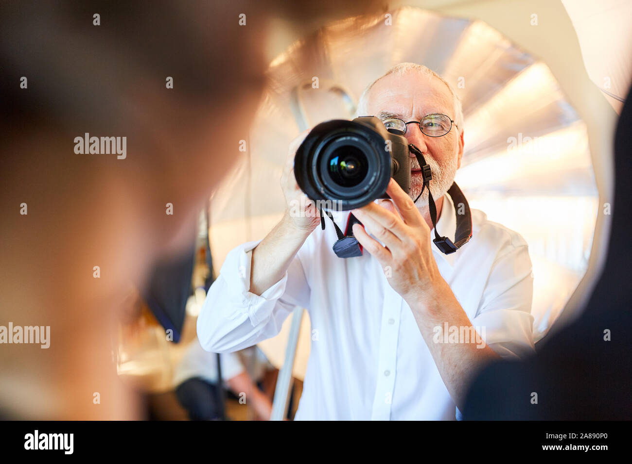 Experienced photographer with camera makes portrait photos of a woman ...