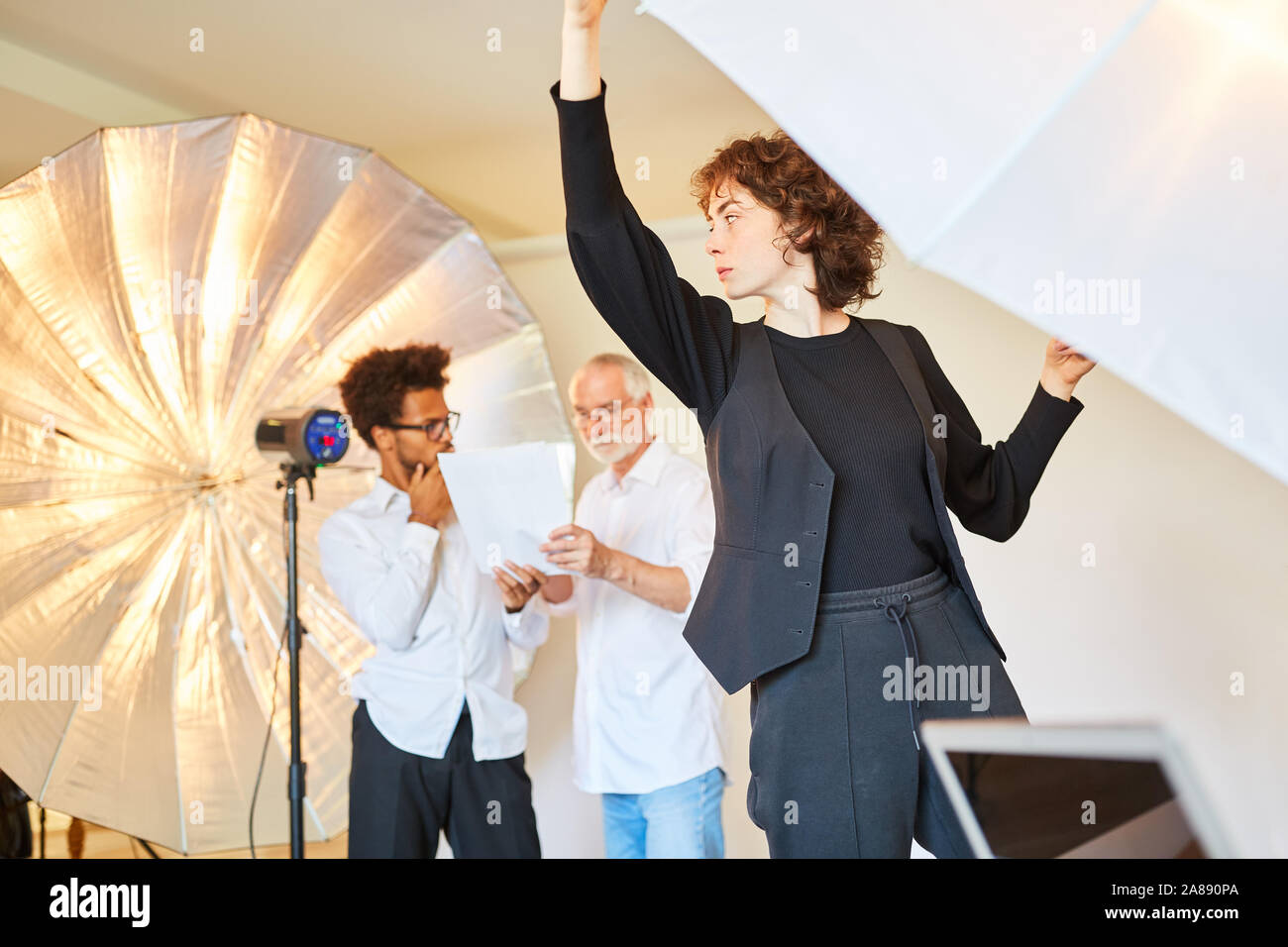 Photographer team with art director and model prepares a photo shoot ...