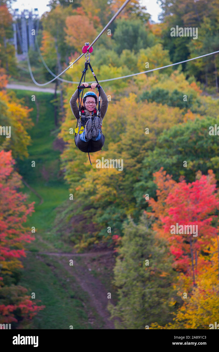 Woman riding a zip line in the fall Stock Photo - Alamy