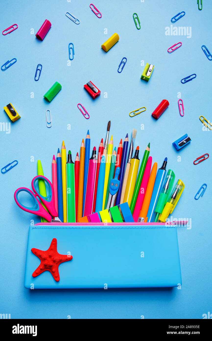 Light blue pencil case with a red star and colored stationery on a blue ...