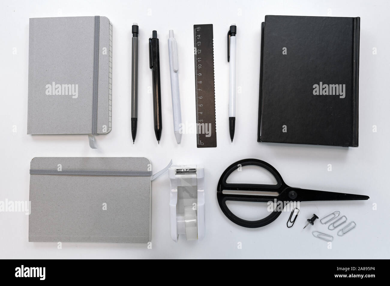 High angle top view of white desk with various black, gray and white ...