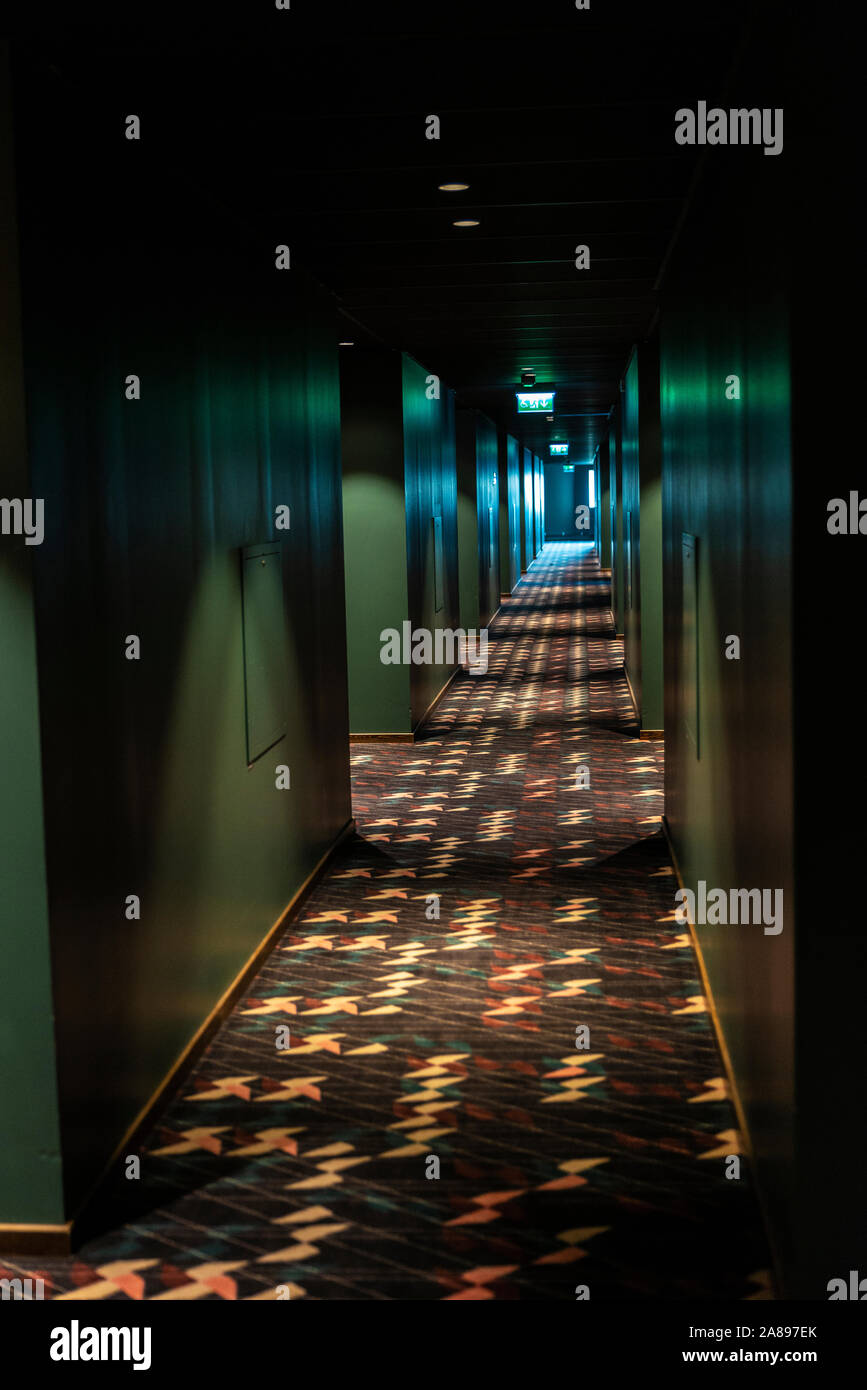 Dark, lonely and dark hallway with light at the end inside a modern ...