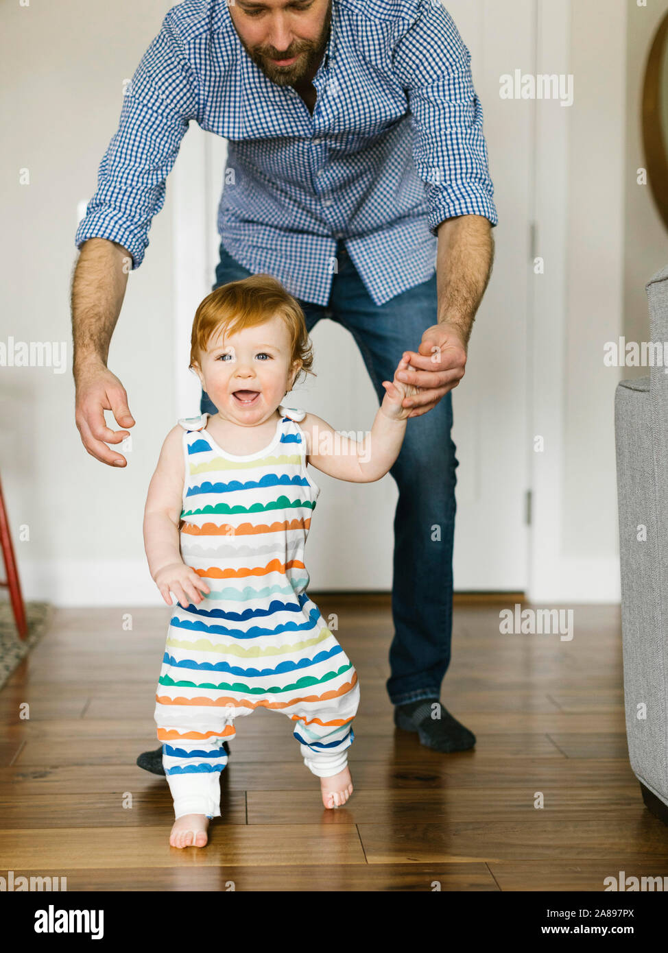 Father helping baby boy to walk Stock Photo - Alamy