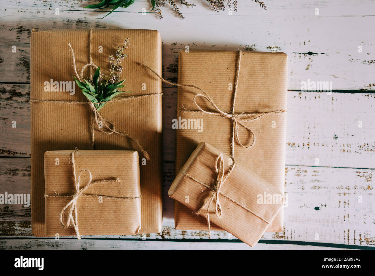 Presents wrapped in brown paper and string with flowers Stock Photo - Alamy