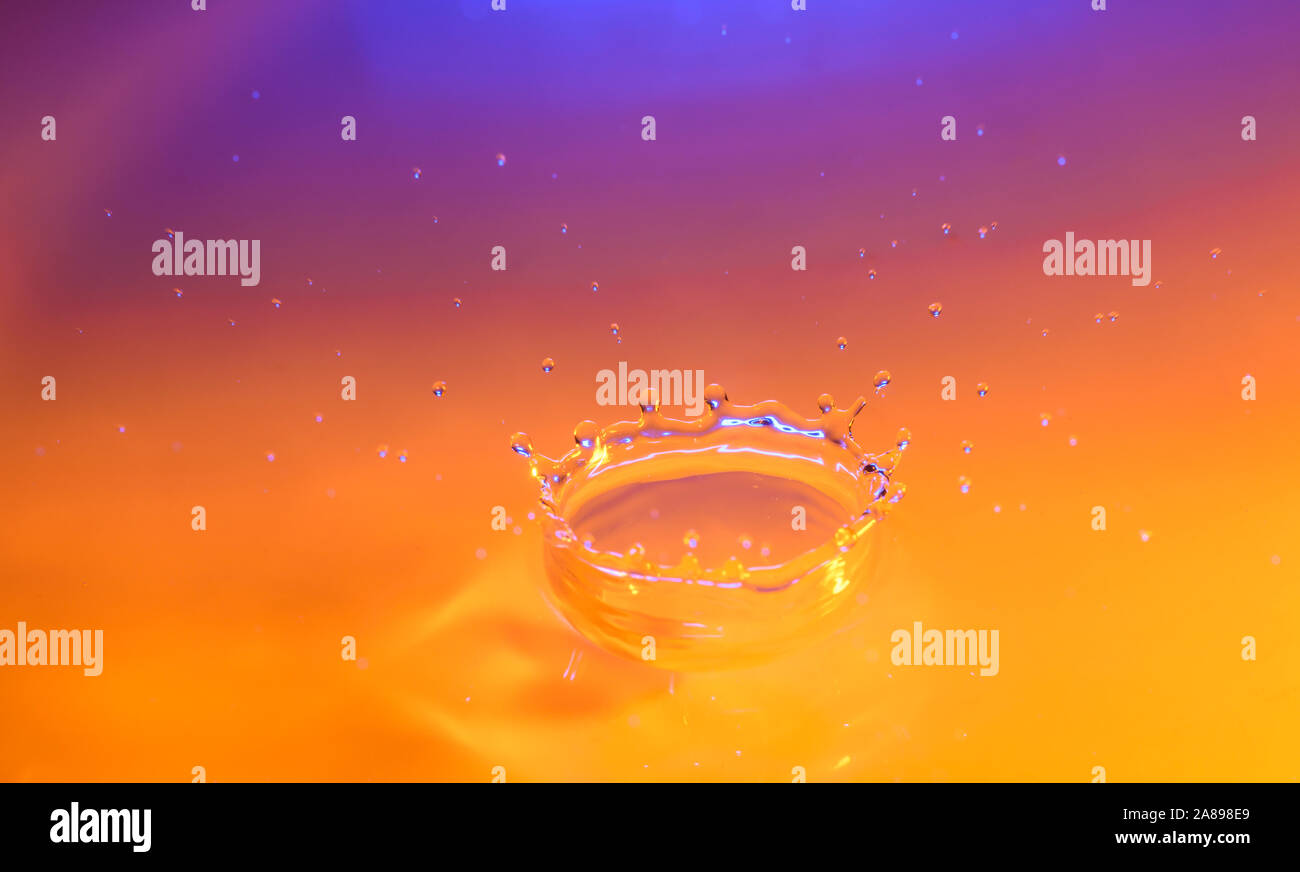 Orange and purple splashing water Stock Photo - Alamy