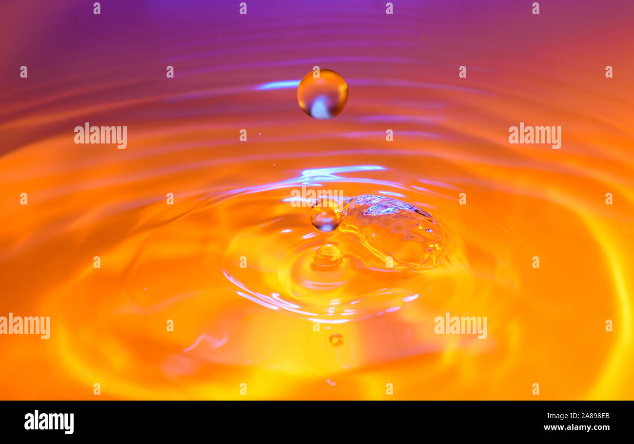 Orange and purple splashing water Stock Photo - Alamy